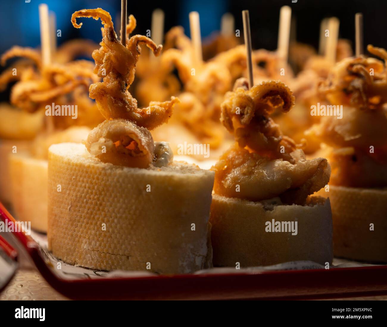 Typical snack of Basque Country, pinchos or pinxtos skewers with small ...
