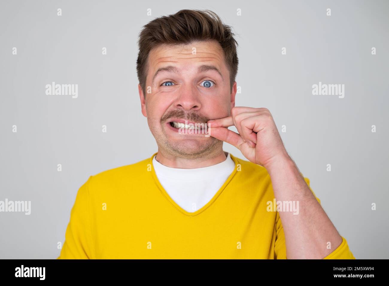 man trying to keep secret. mouth and lips shut as zip with fingers ...