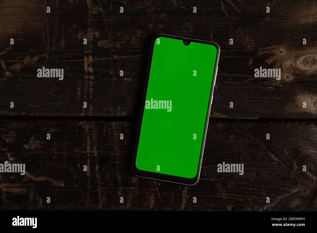 phone with green screen on a wooden table, mobile phone, place for text ...
