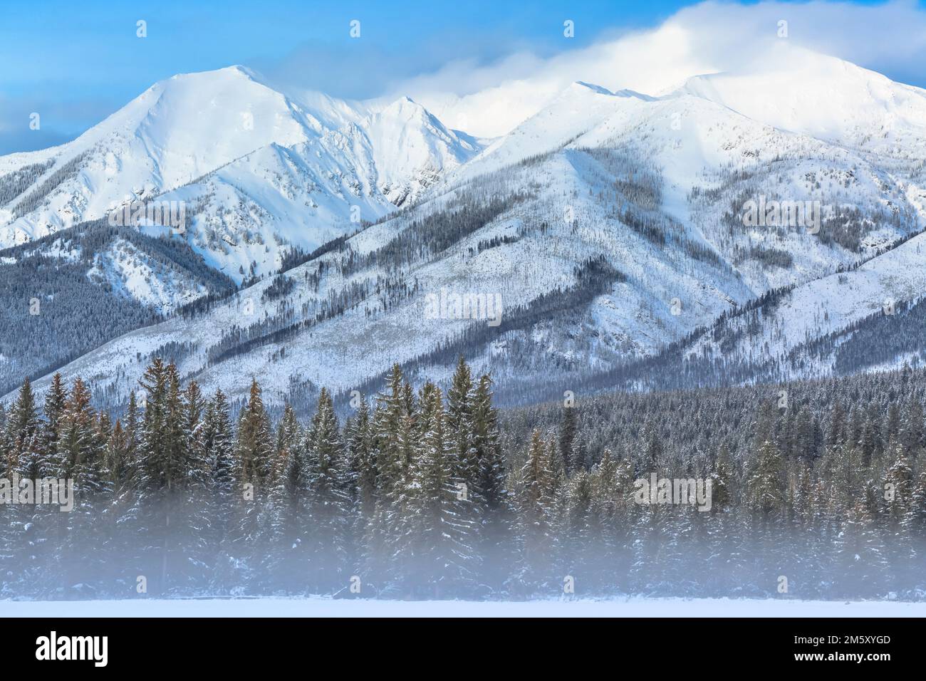 ground fog building in the evening chill below peaks of the swan range ...