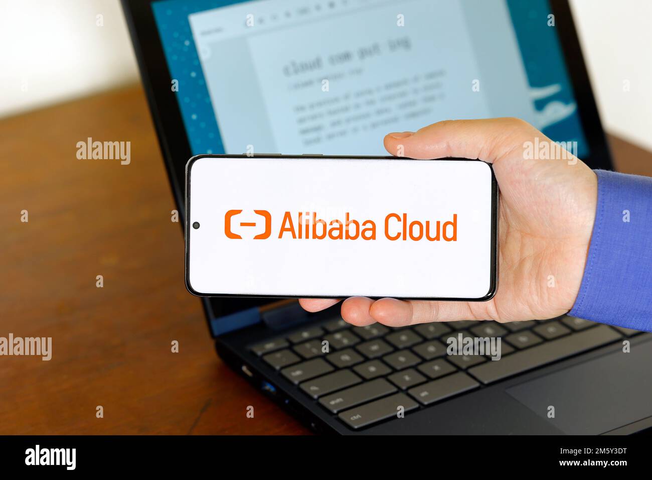 Logo of Alibaba Cloud on a smartphone in front of a computer. Alibaba ...
