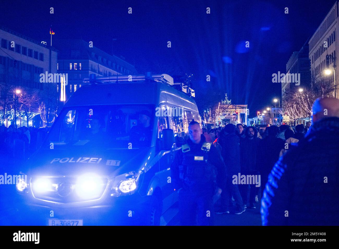 Berlin, Germany. 31st Dec, 2022. A police car drives through the crowd ...