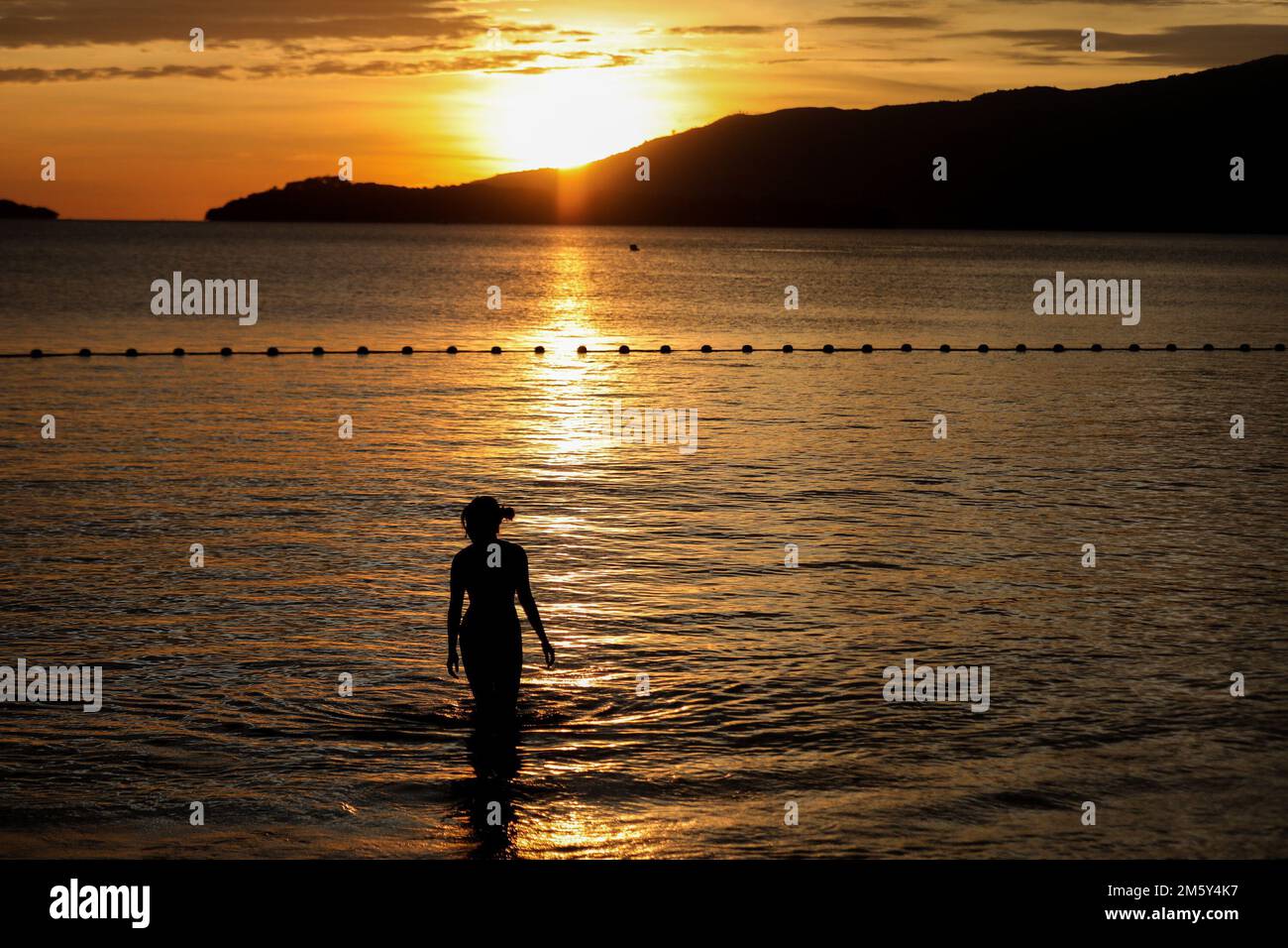 Manila, Philippines. 31st Dec, 2022. A woman walks along the shoreline ...