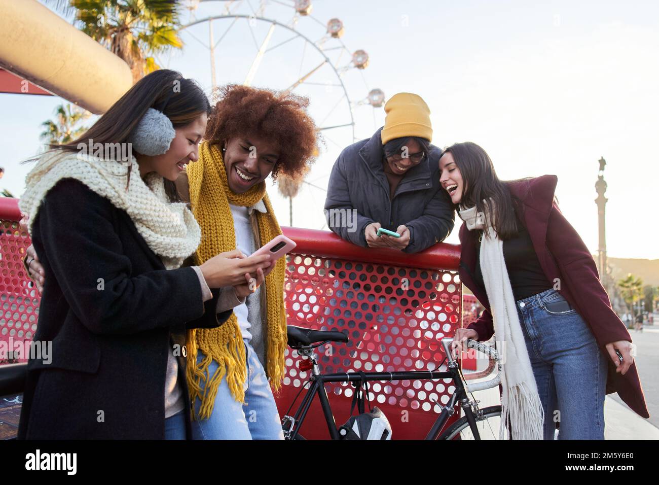 Group of young mixed race people in winter clothes with cell phones ...