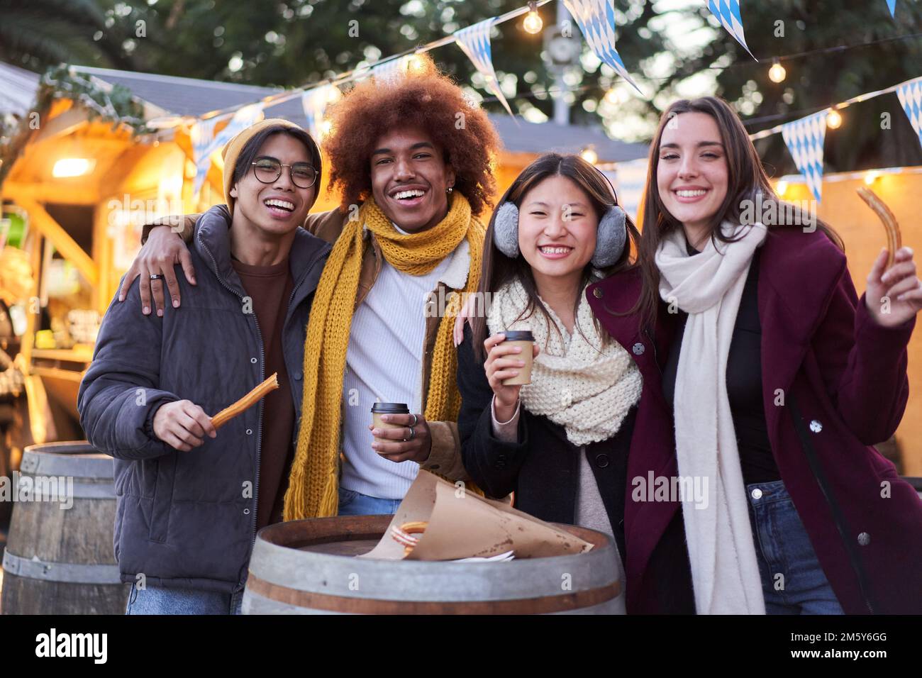 Happy friends eating chocolate with churros street food at the city in ...