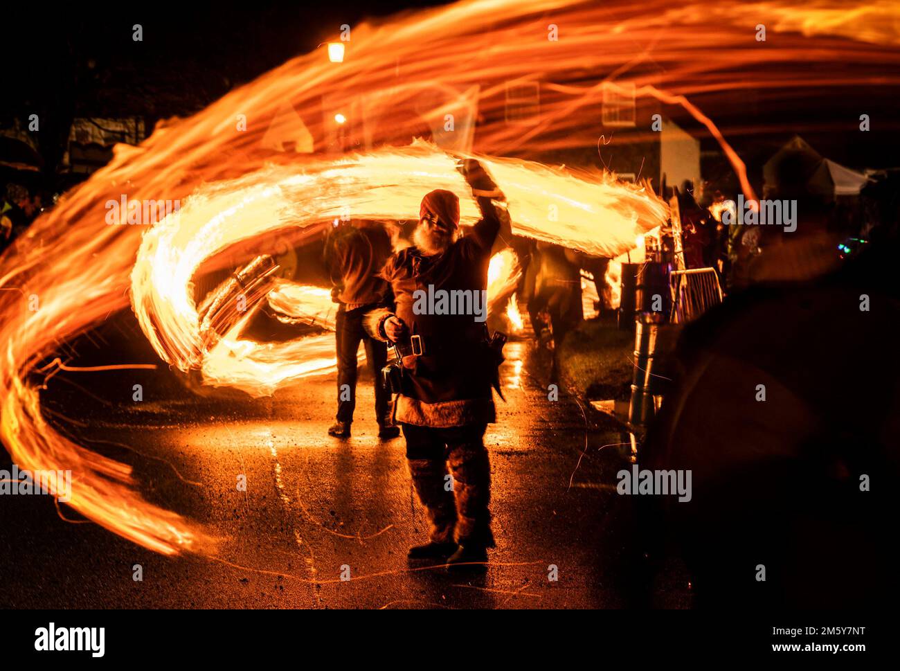 A performer swings a fireball during the Flamborough Fire Festival, a ...