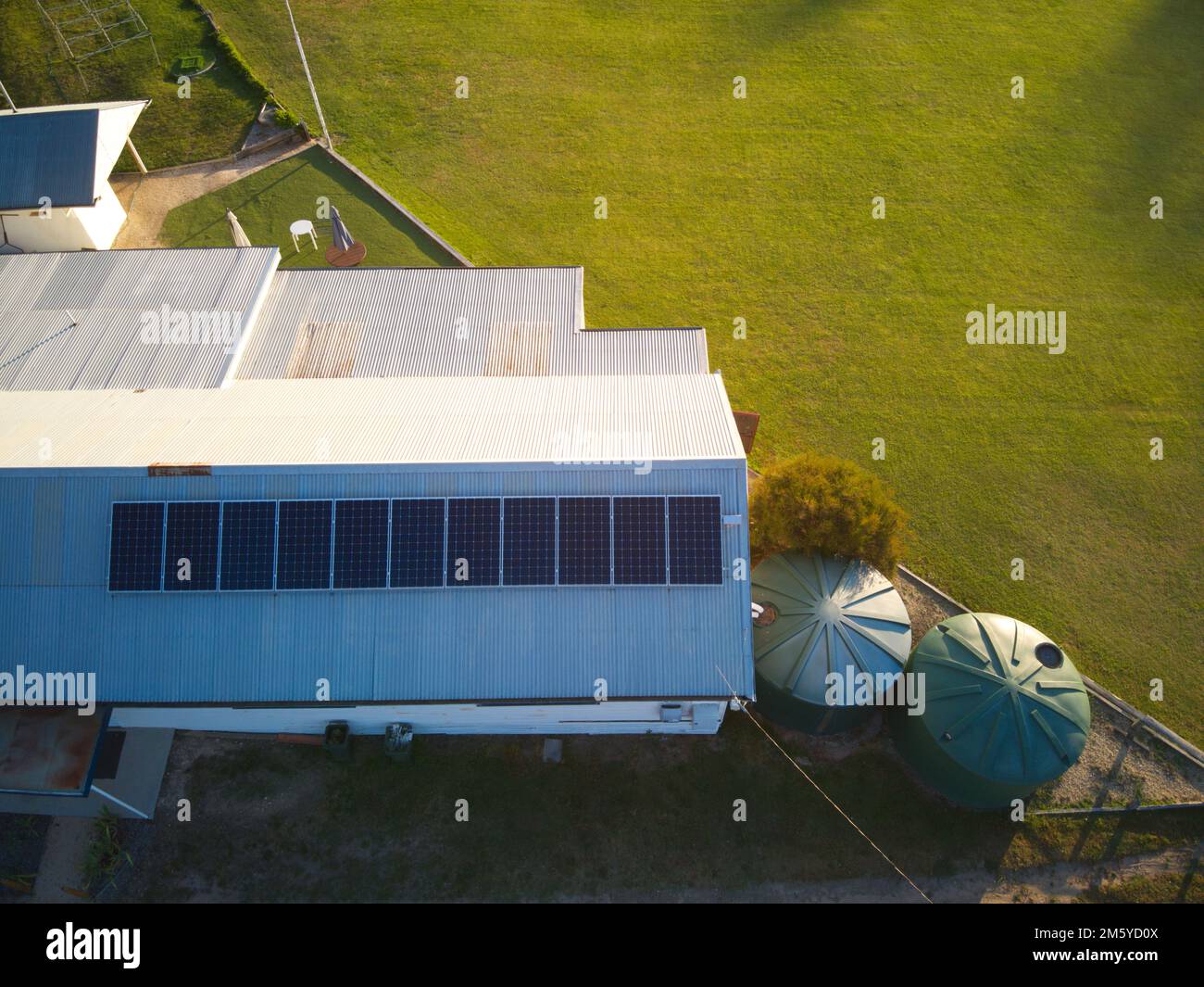 Solar panels aerial view on a building roof with green lawn playing ...
