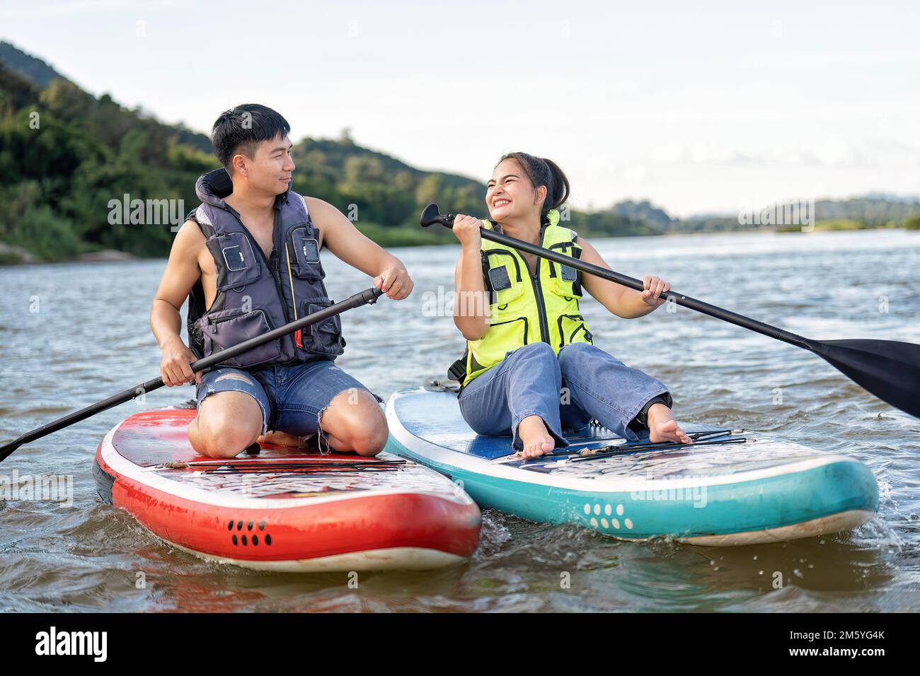 On summer holiday love couple relax sail sup board surf on river on ...