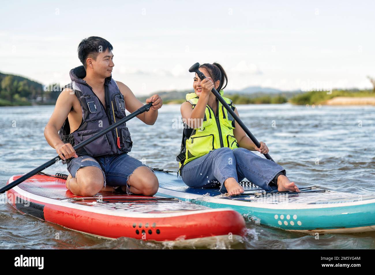 On summer holiday love couple relax sail sup board surf on river on ...