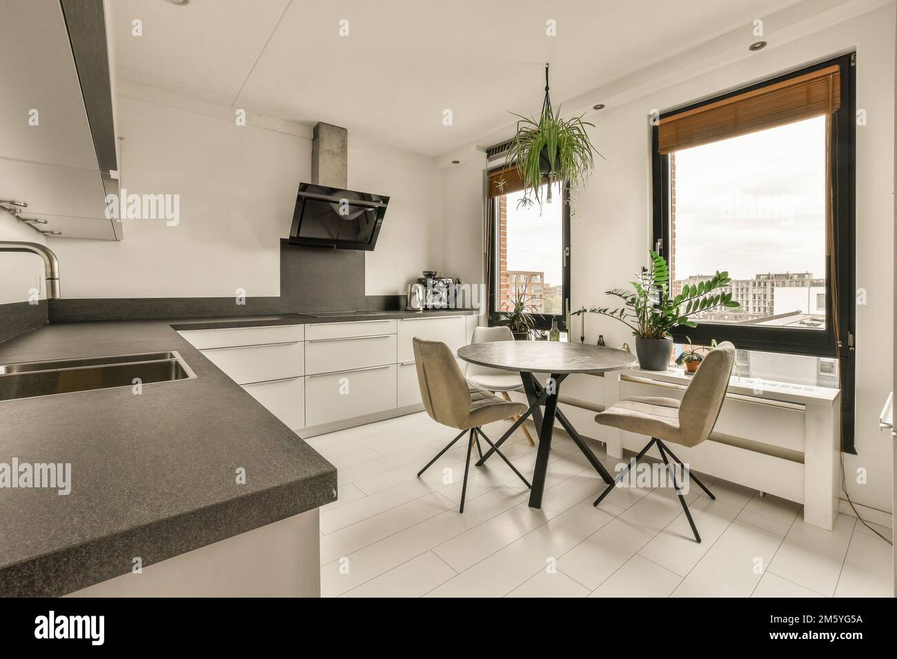 a kitchen and dining area in a modern apartment with white cabinets ...