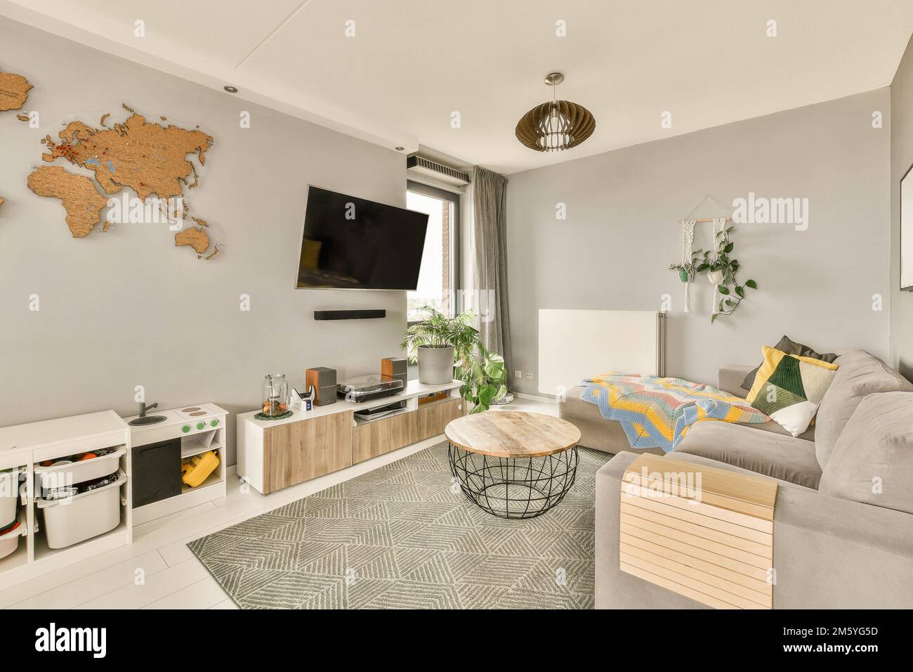 a living room with a map on the wall and a grey couch, coffee table ...