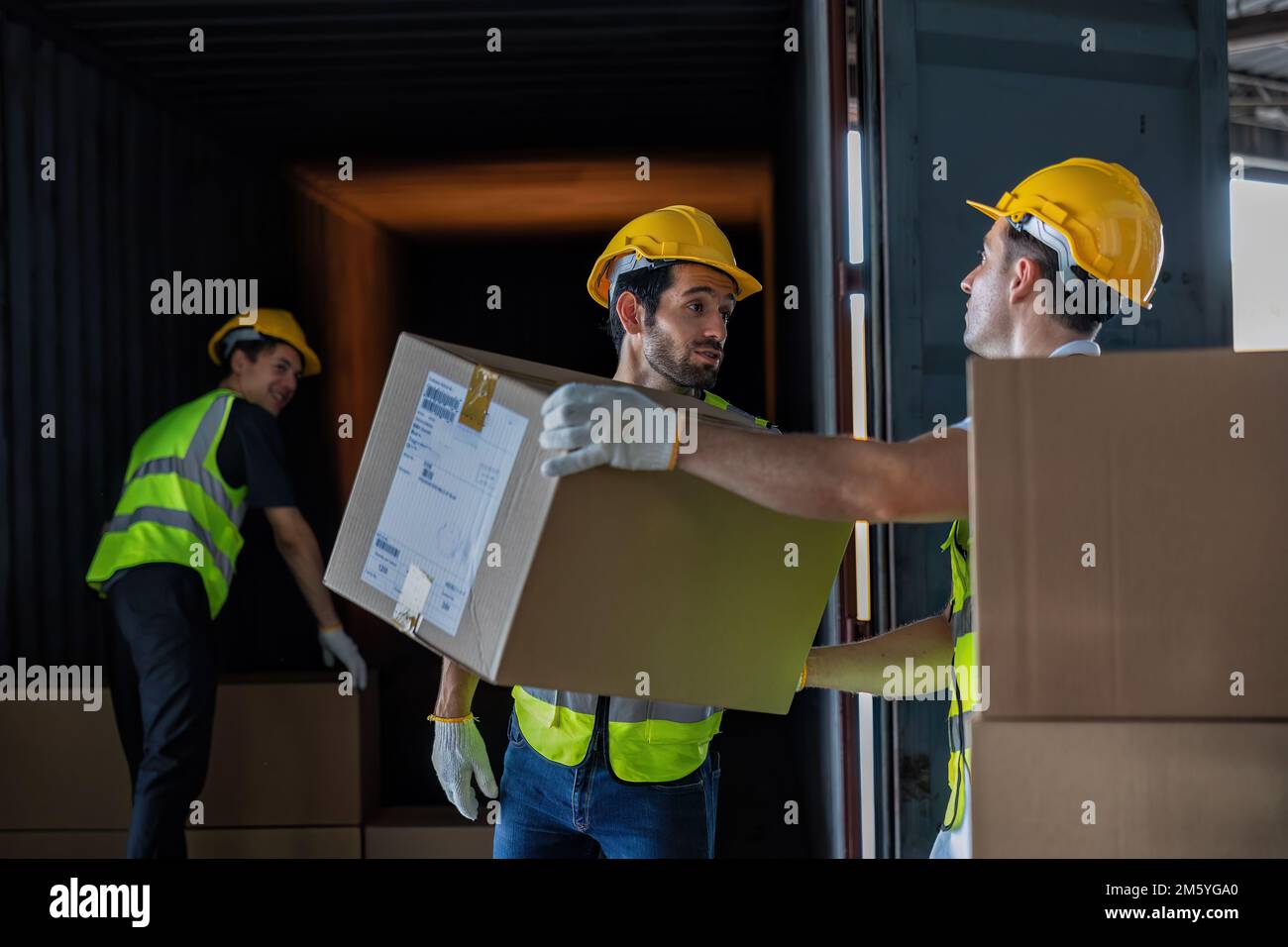 Worker carry carton box taken from 40 feet steel container on the ...