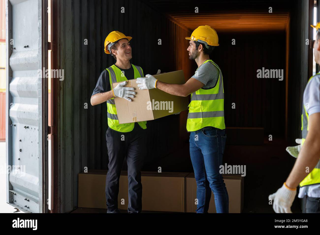 Worker carry carton box taken from 40 feet steel container on the ...