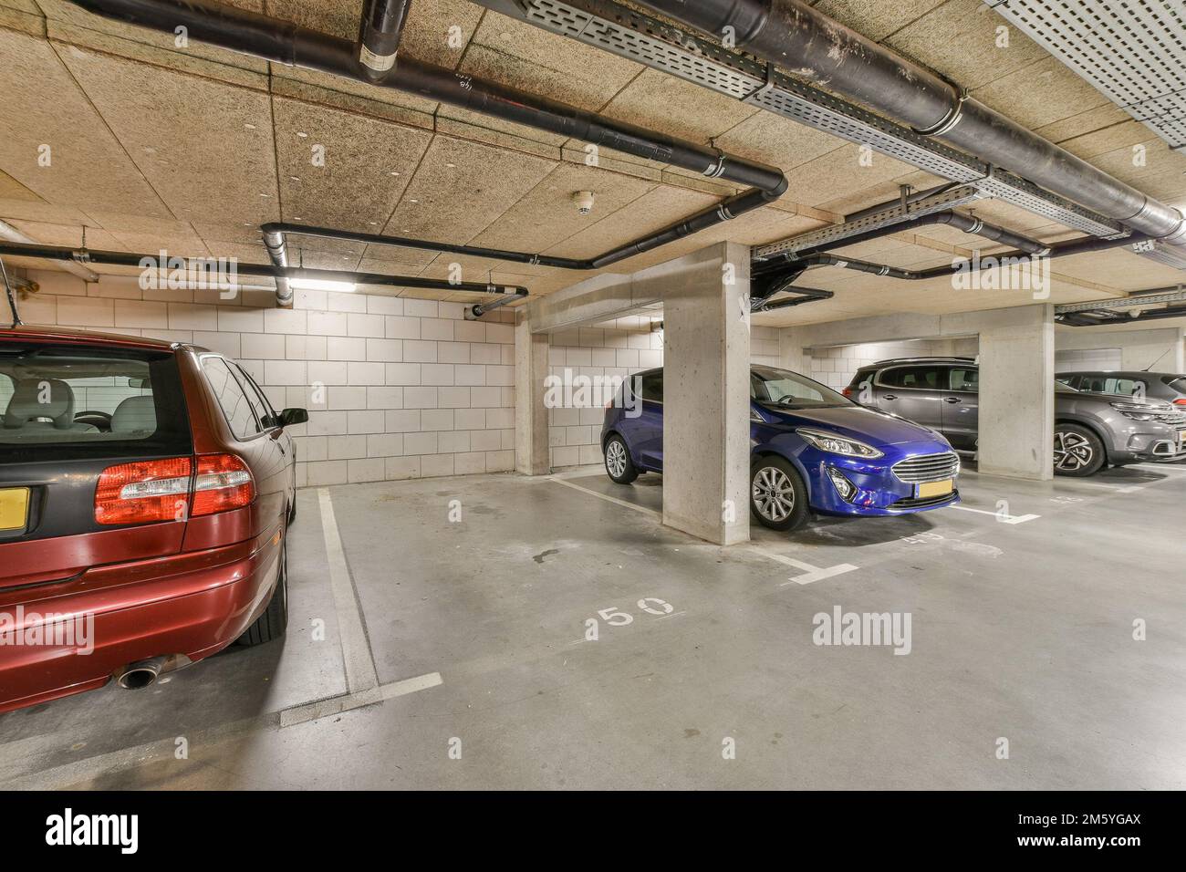 an underground parking area with cars parked in the space and two ...