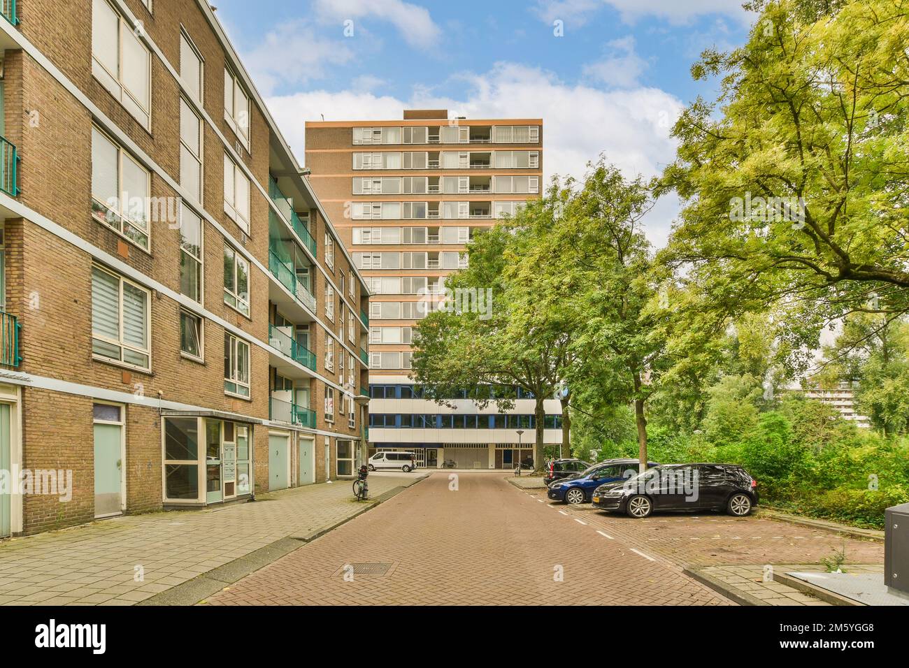 a city street with cars parked on the side and buildings in the back ...