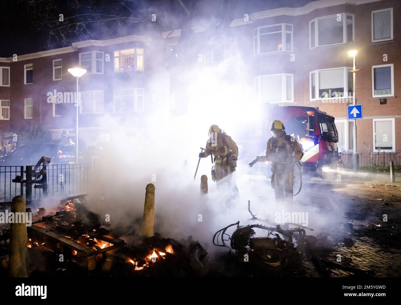 THE HAGUE - Firefighters extinguish a fire while being protected by the ...