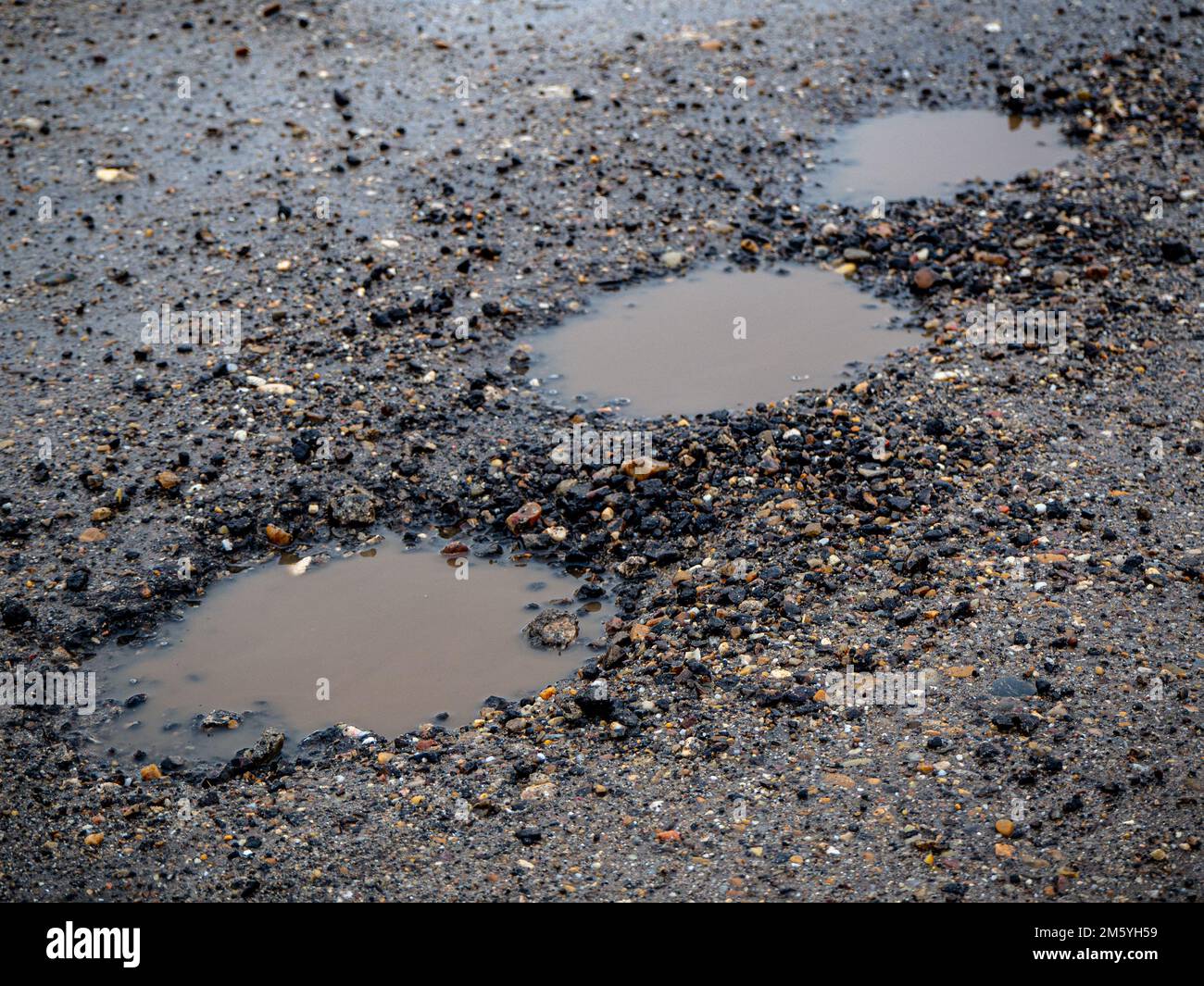 Pothole on a paved road on a rainy winter day. Concept of risk and ...