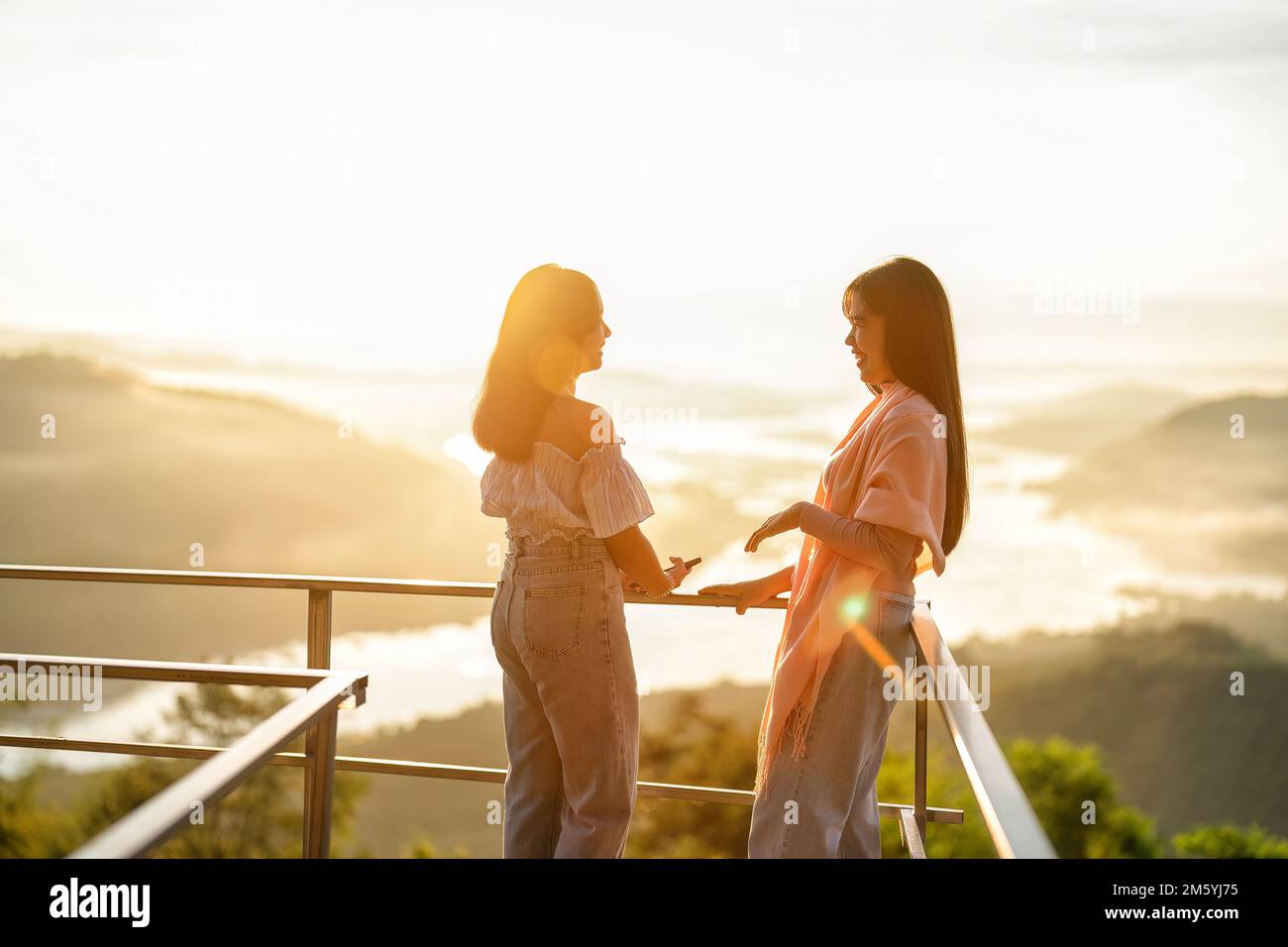 Sunrise morning 2 traveler girls happy talking mountain view platform ...