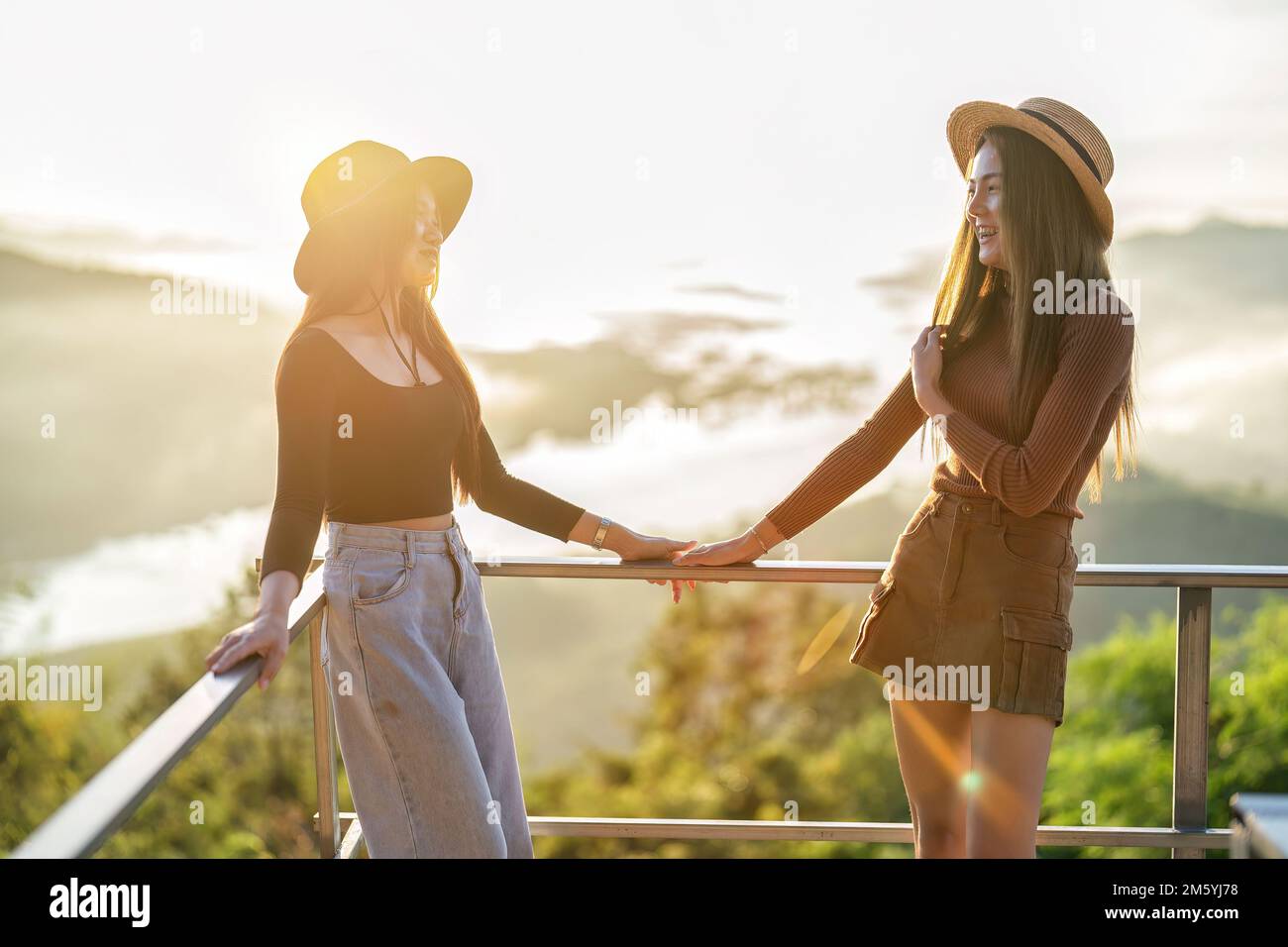 Sunrise morning 2 traveler girls happy talking mountain view platform ...