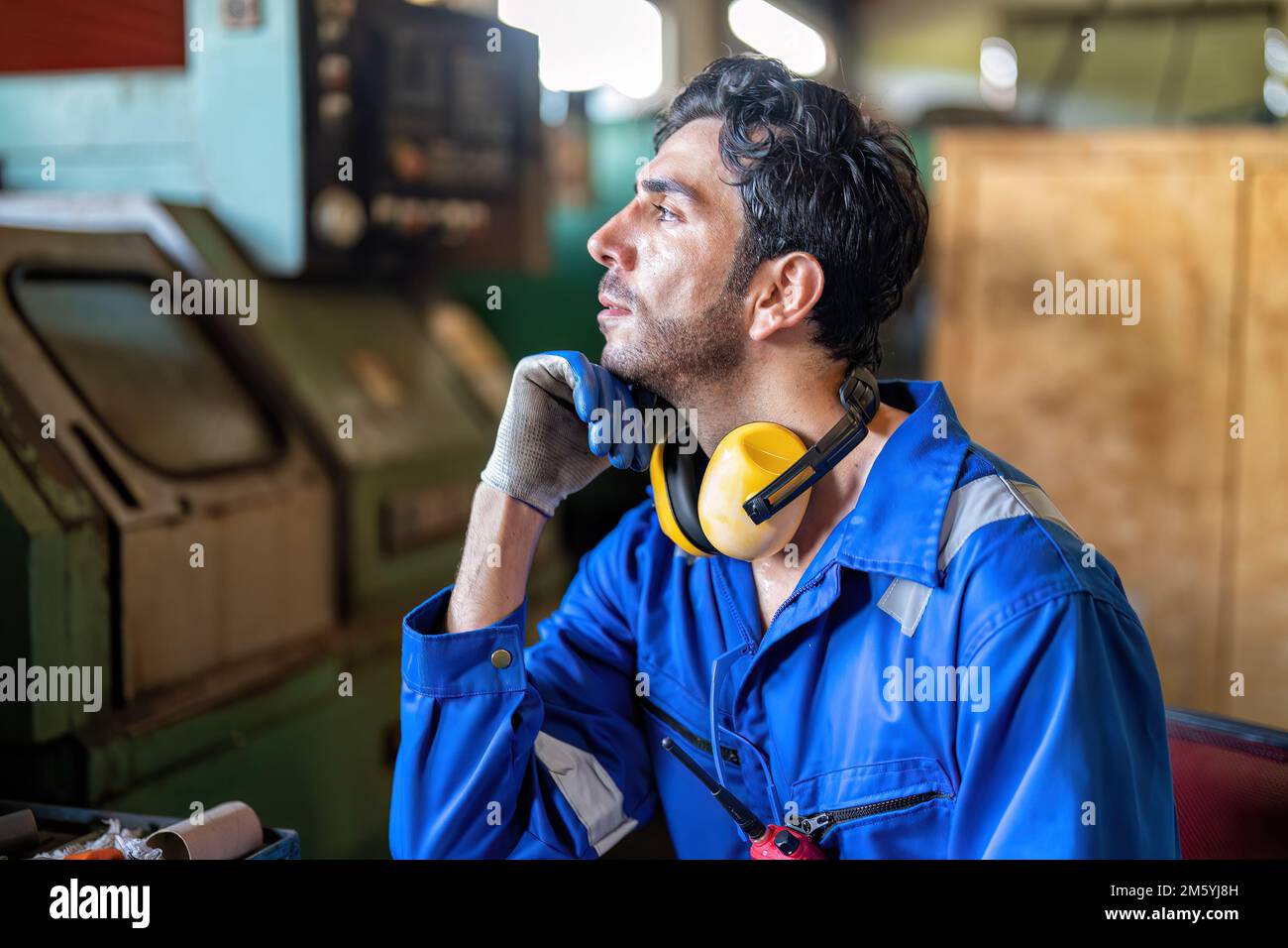 Mechanical man in uniform on break time sitting look over window heavy ...