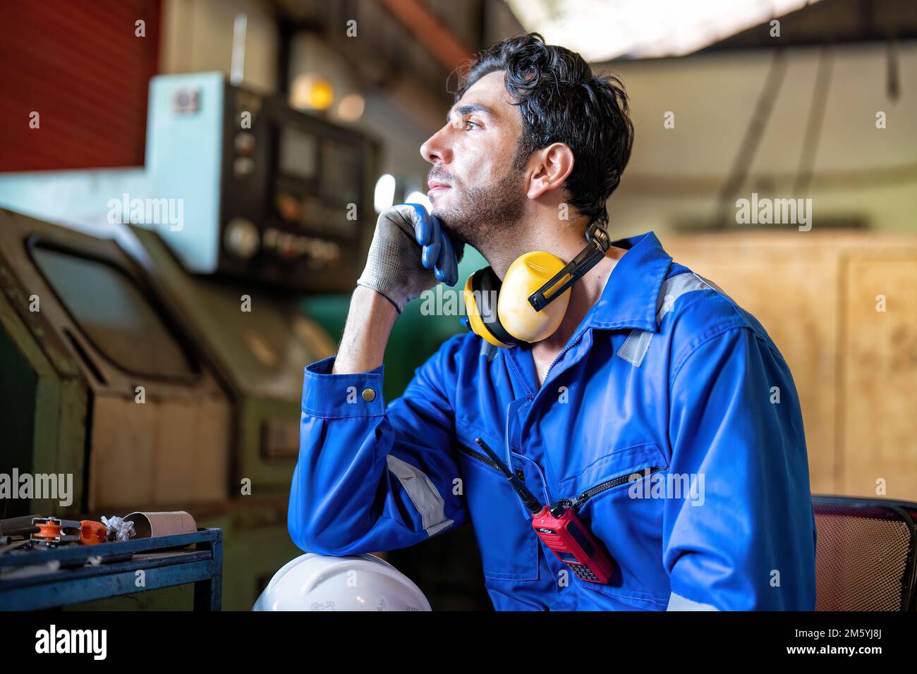 Mechanical man in uniform on break time sitting look over window heavy ...