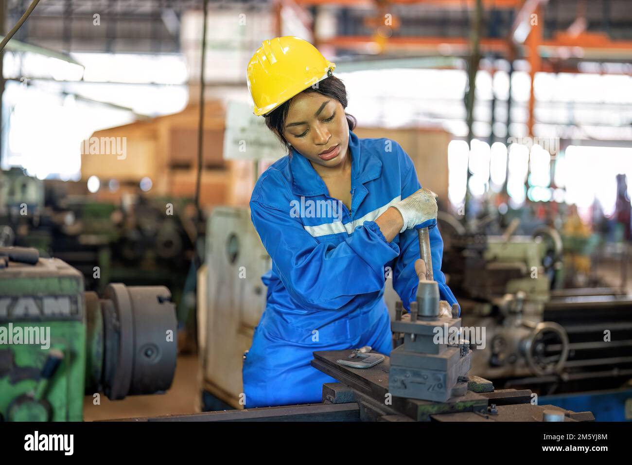 Woman worker in uniform operating machine at factory concentrate on ...