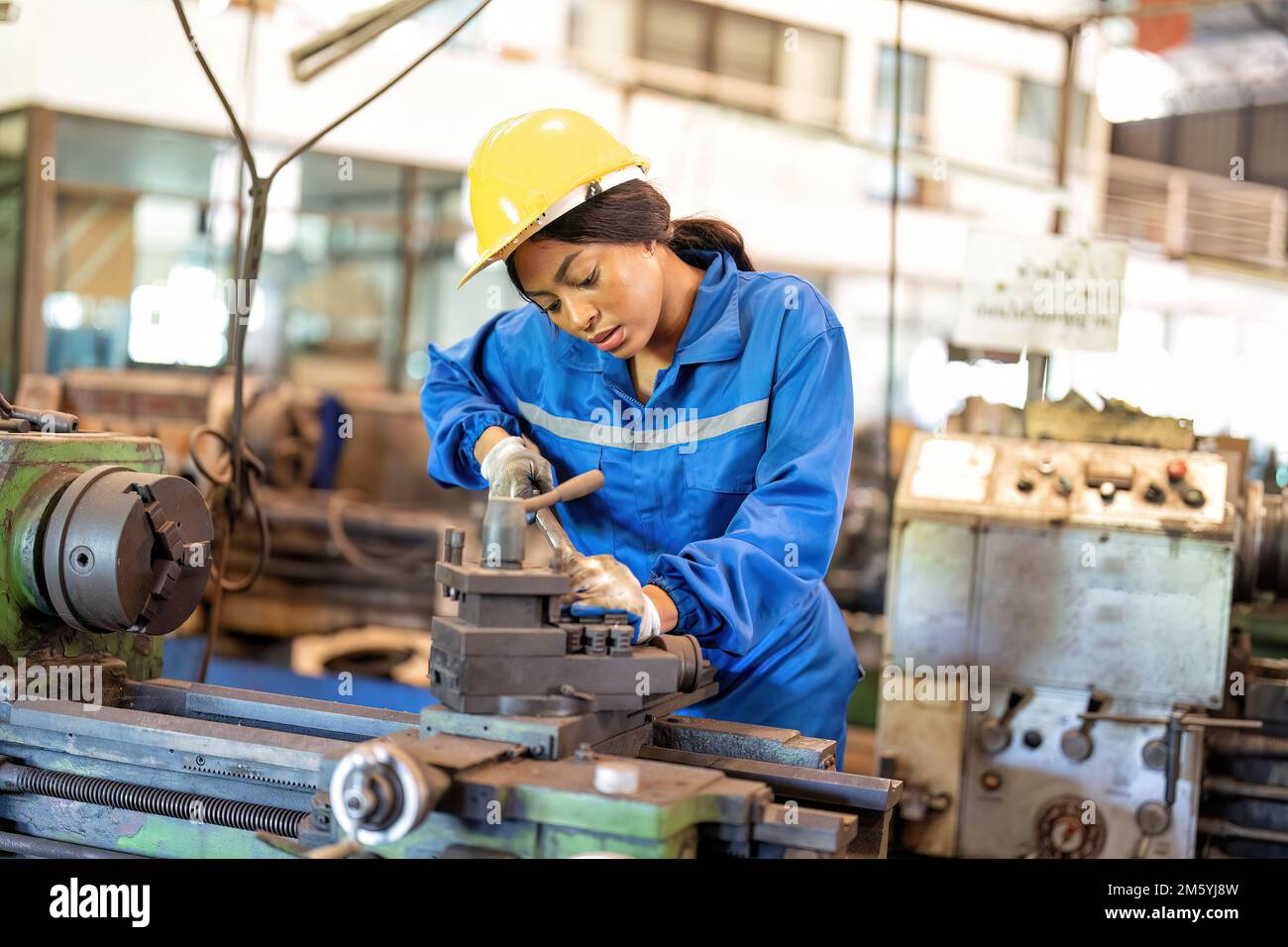 Woman worker in uniform operating machine at factory concentrate on ...