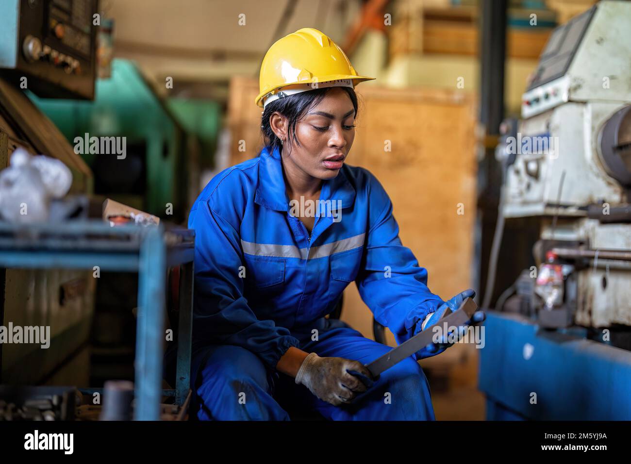 Mechanical girl in uniform on break time sitting check F wrench and ...