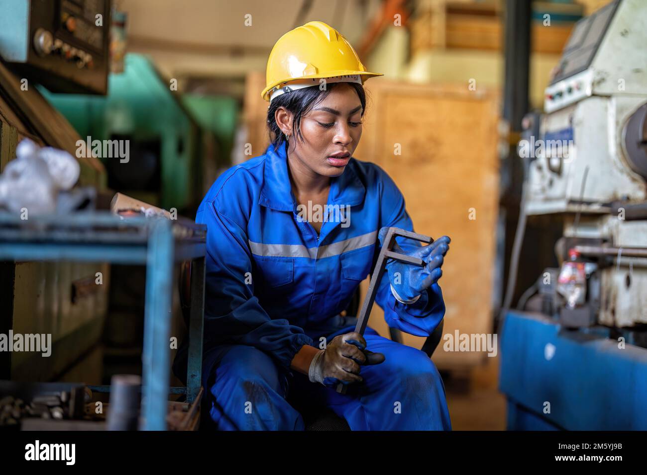 Mechanical girl in uniform on break time sitting check F wrench and ...