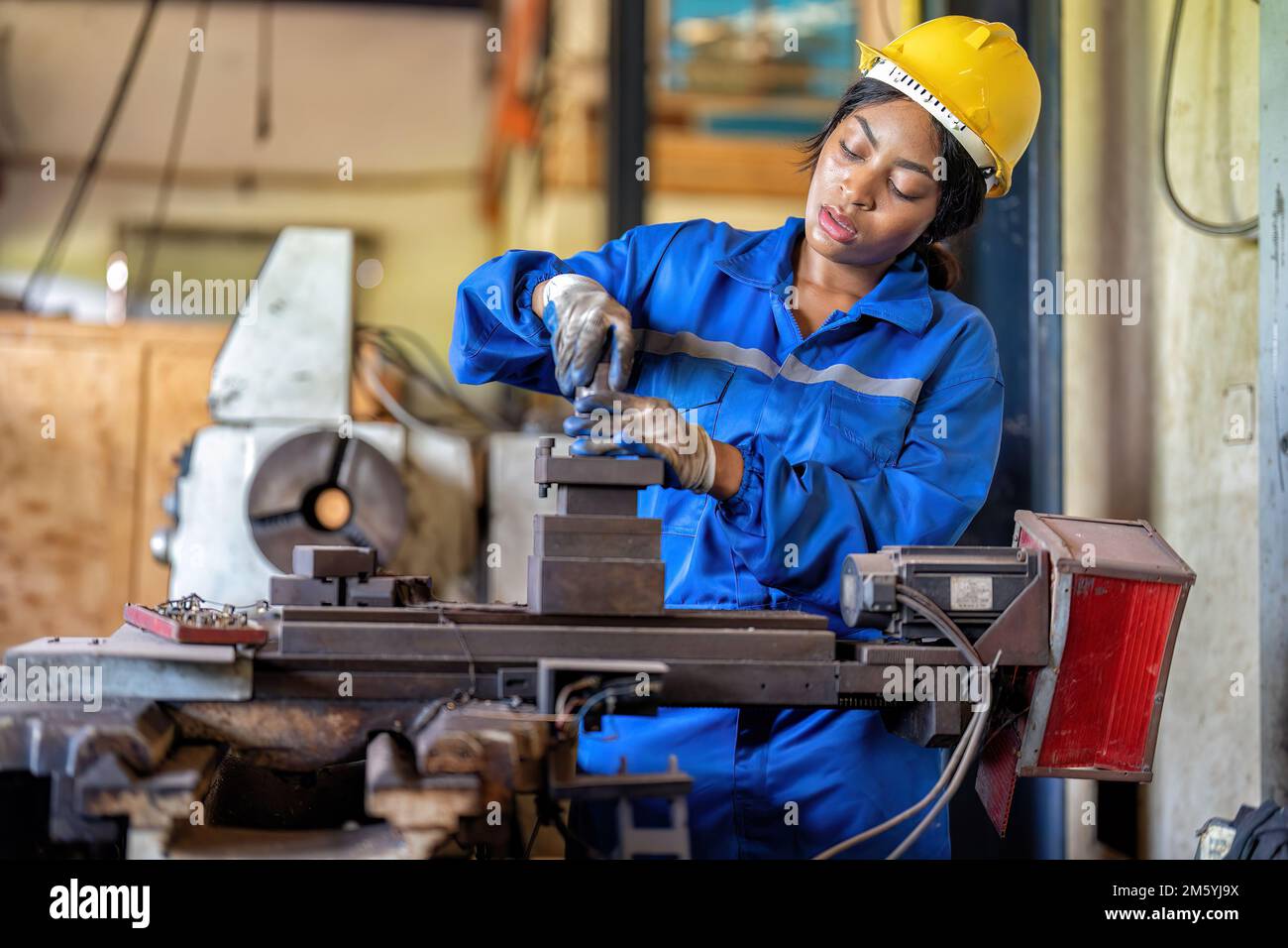 Woman worker in uniform operating machine at factory concentrate on ...