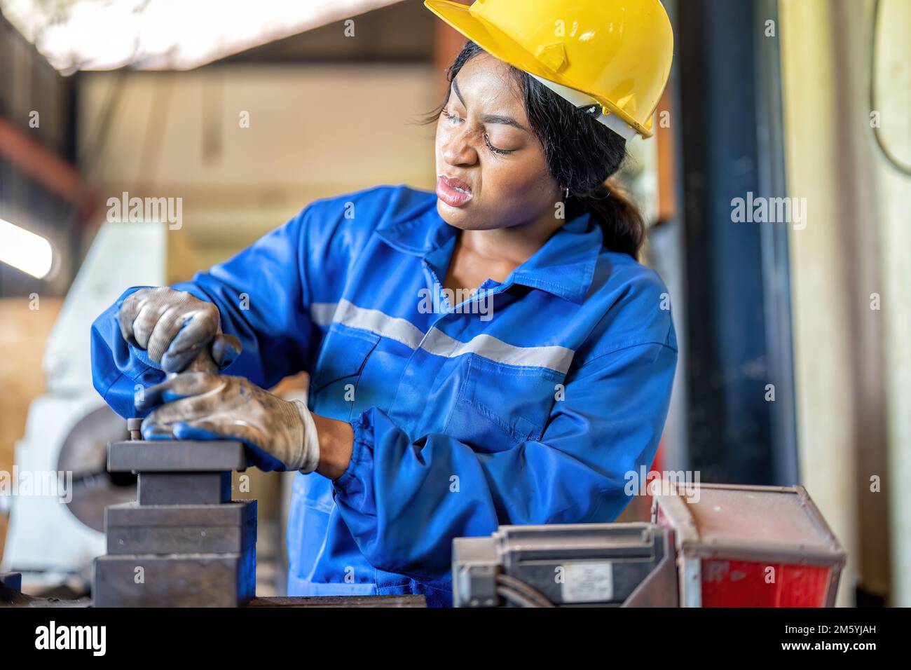 Woman worker in uniform operating machine at factory concentrate on ...