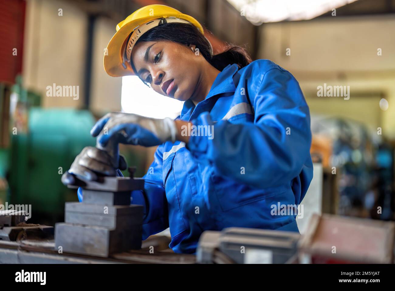 Woman worker in uniform operating machine at factory concentrate on ...