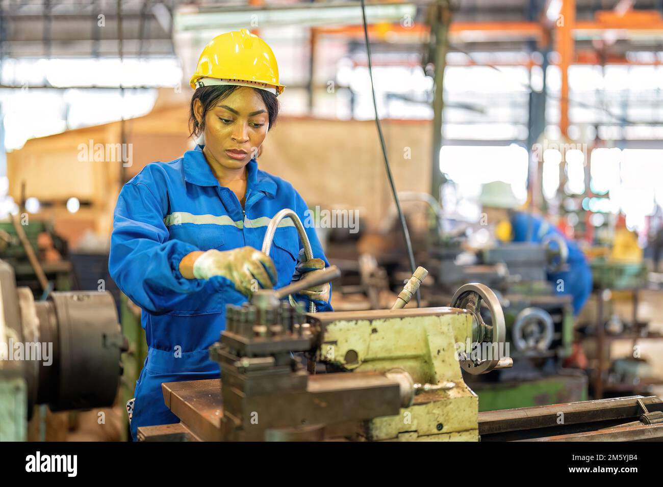 Woman worker in uniform operating machine at factory concentrate on ...