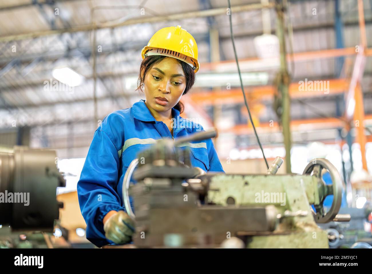 Woman worker in uniform operating machine at factory concentrate on ...