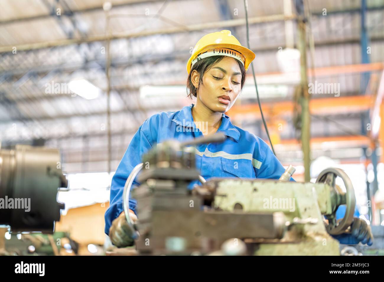 Woman worker in uniform operating machine at factory concentrate on ...
