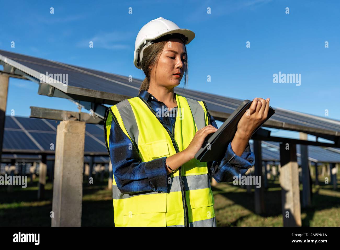 Maintenance engineer at greenery Solar farm at work hold tablet ...