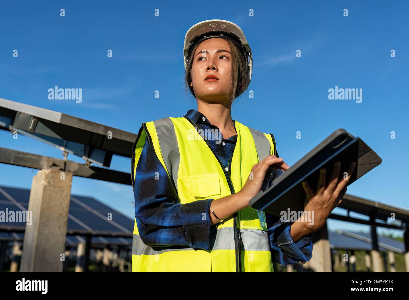 Maintenance engineer at greenery Solar farm at work hold tablet ...
