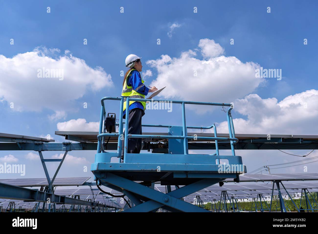 Maintenance engineer at solar farm stand on scissor lift hold check ...
