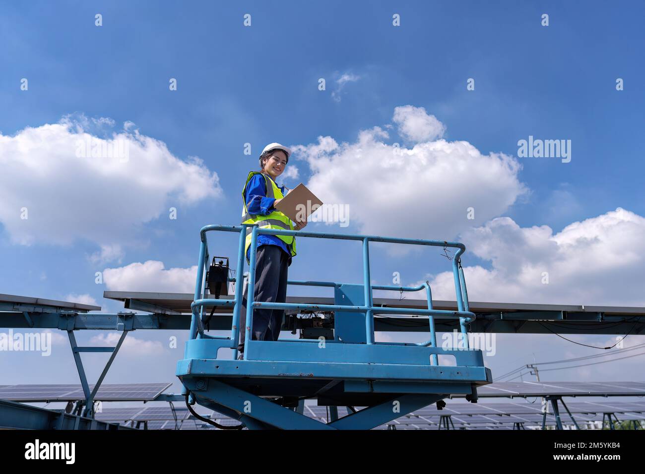 Maintenance engineer at solar farm stand on scissor lift hold check ...