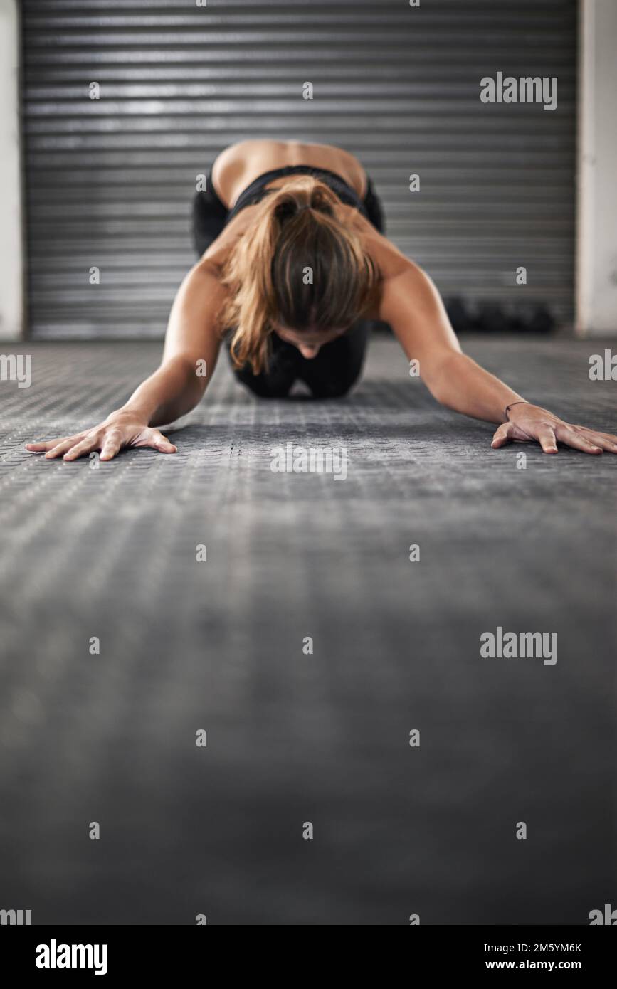 Stretch yourself. a young woman doing stretching exercises at the gym ...