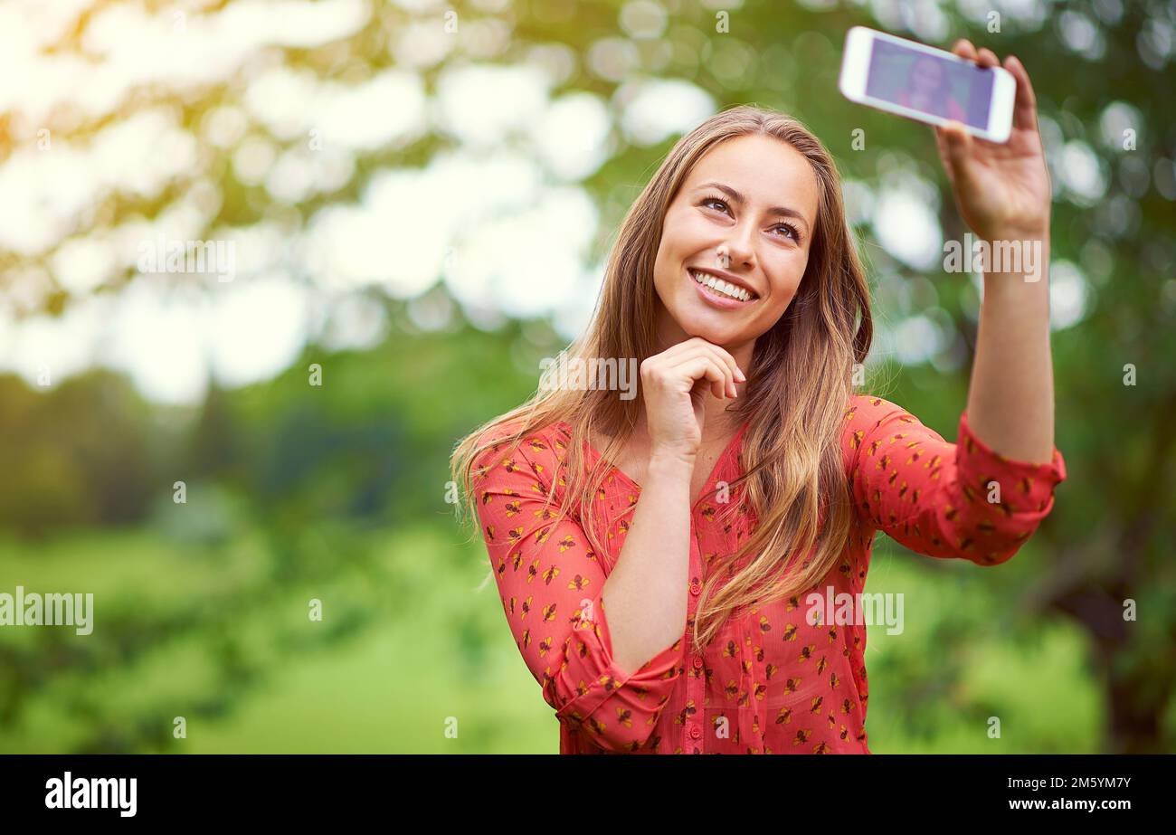 Theres always time for a selfie. a young woman taking a selfie outside ...