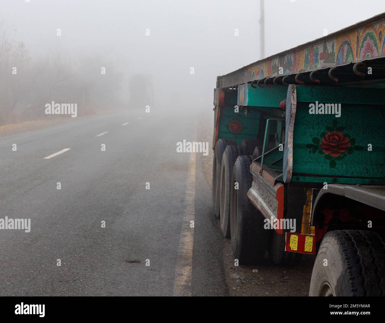 Trailer parked on a roadside in a thick fog with poor visibility in ...