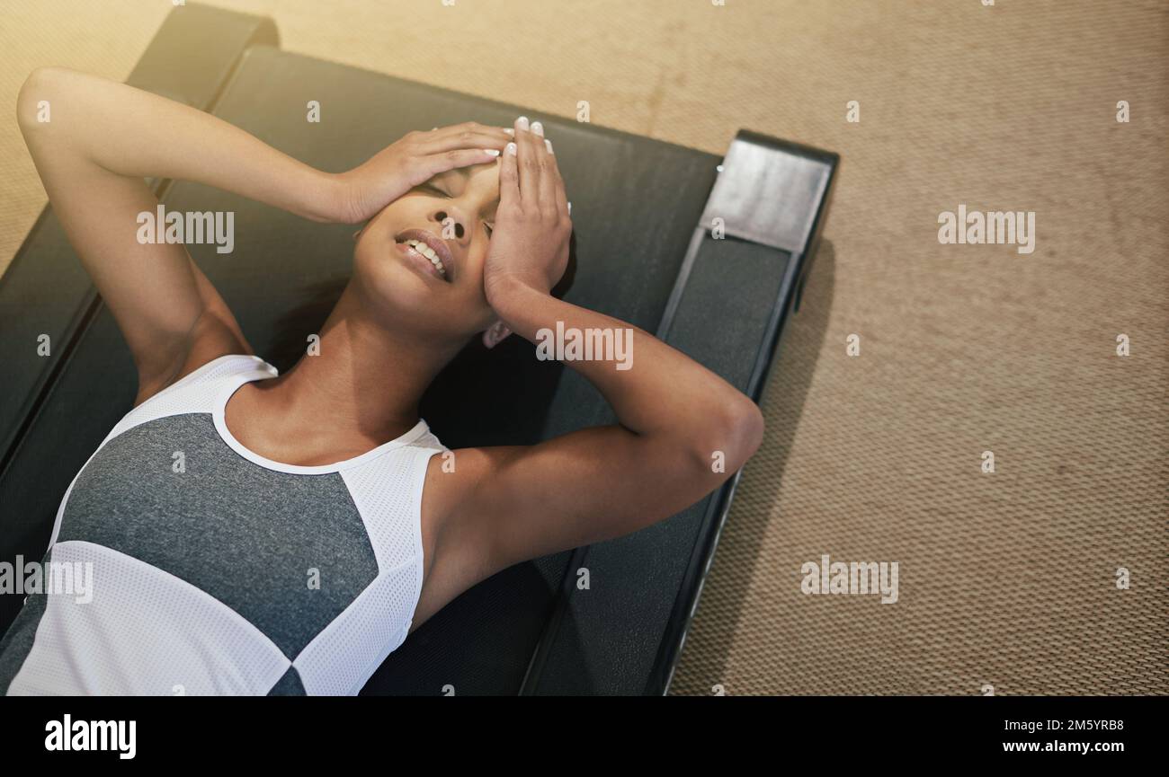 That was intense. a young woman lying on a treadmill after an intense ...