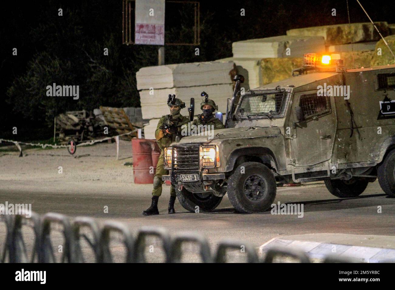 Israeli army forces block the street in front of Palestinians while guarding a march of Jewish ...