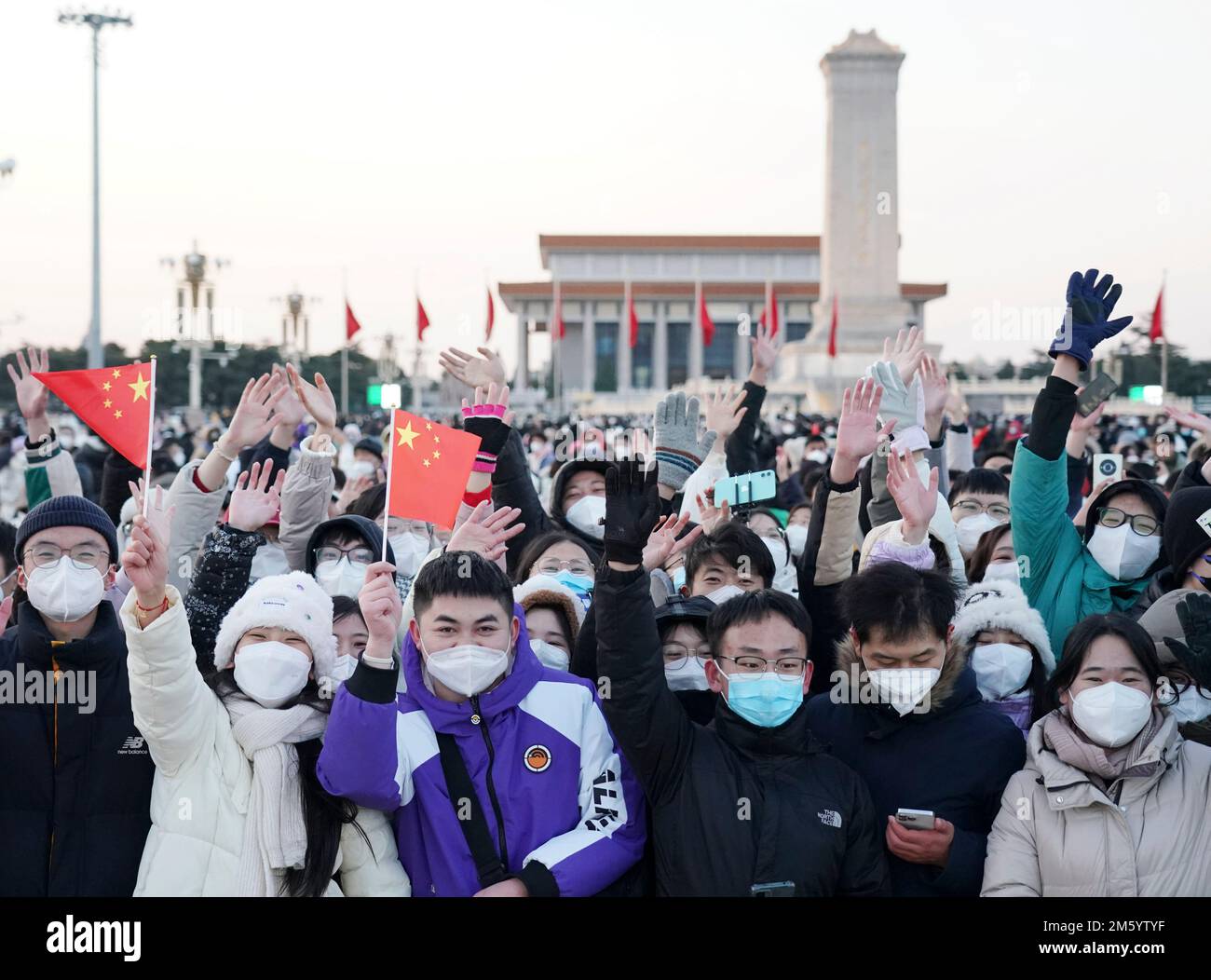 Beijing, China. 1st Jan, 2023. People cheer after a national flag ...