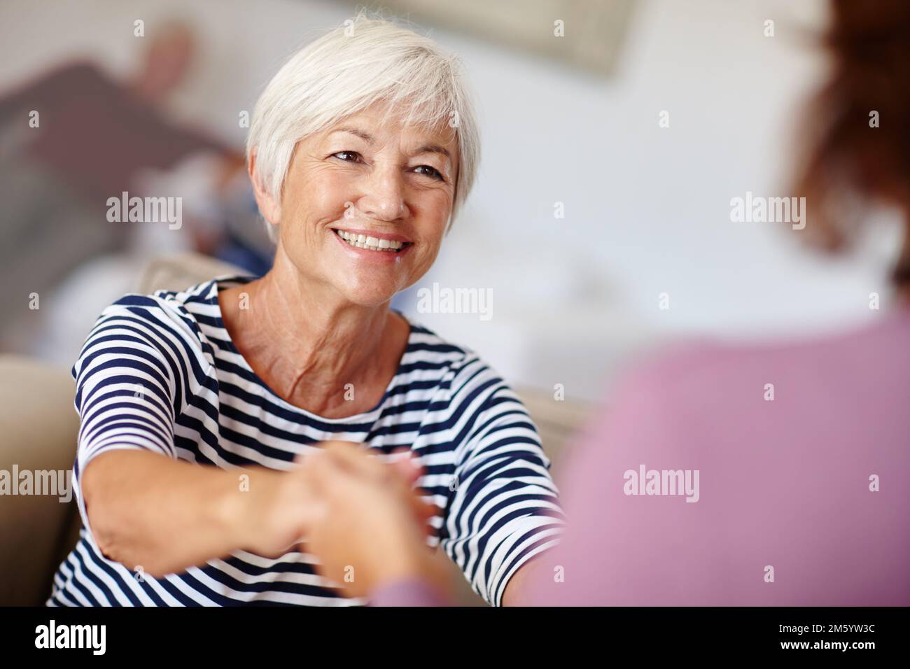 Feeling loved...a senior woman holding her daughters hand Stock Photo ...