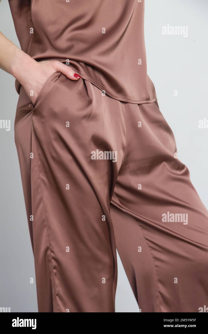 Serie of studio photos of young female model in brown silk outfit set ...