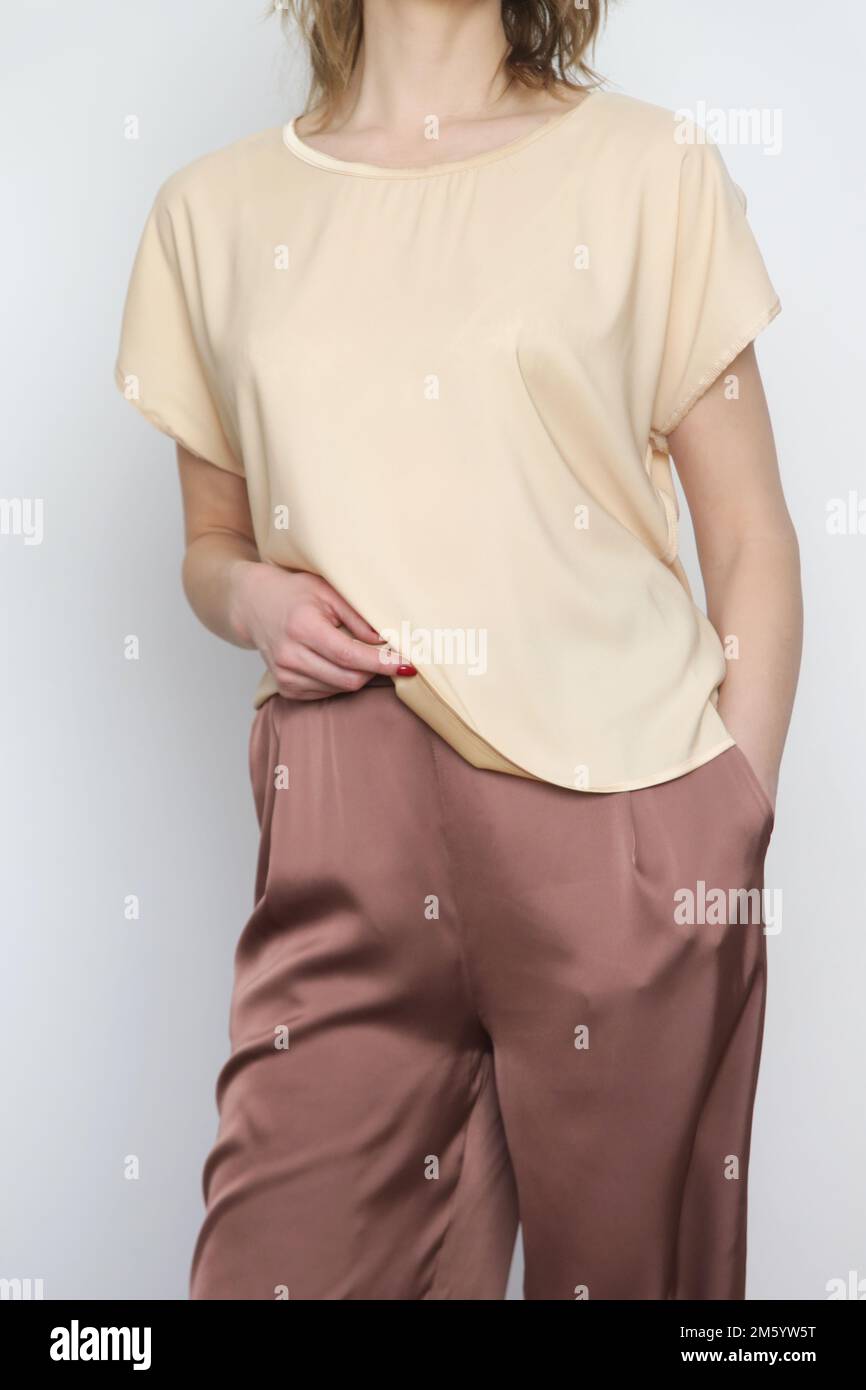 Serie of studio photos of young female model in beige silk outfit Stock ...