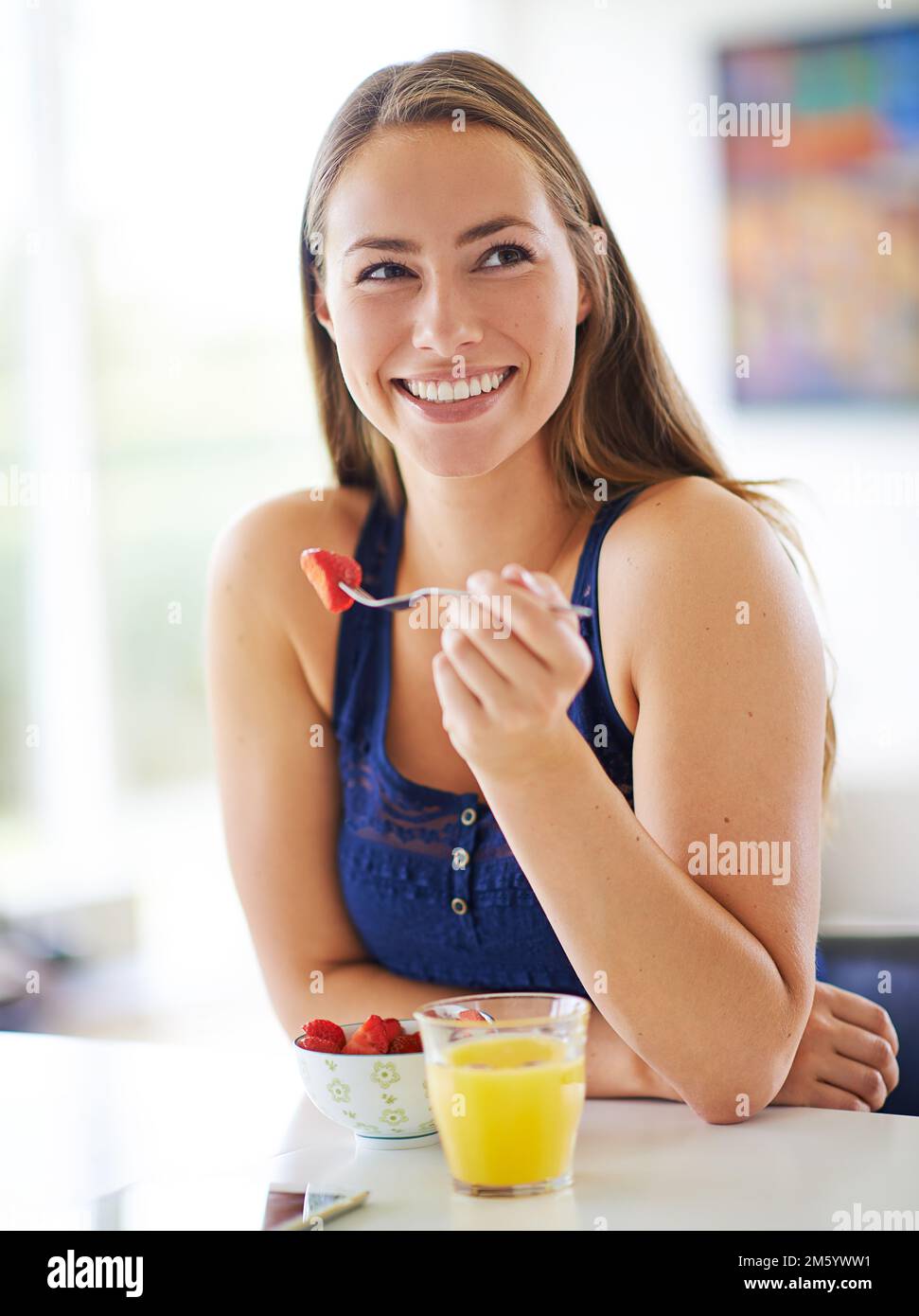 She has something sweet on her mind...a young woman eating a bowl of ...