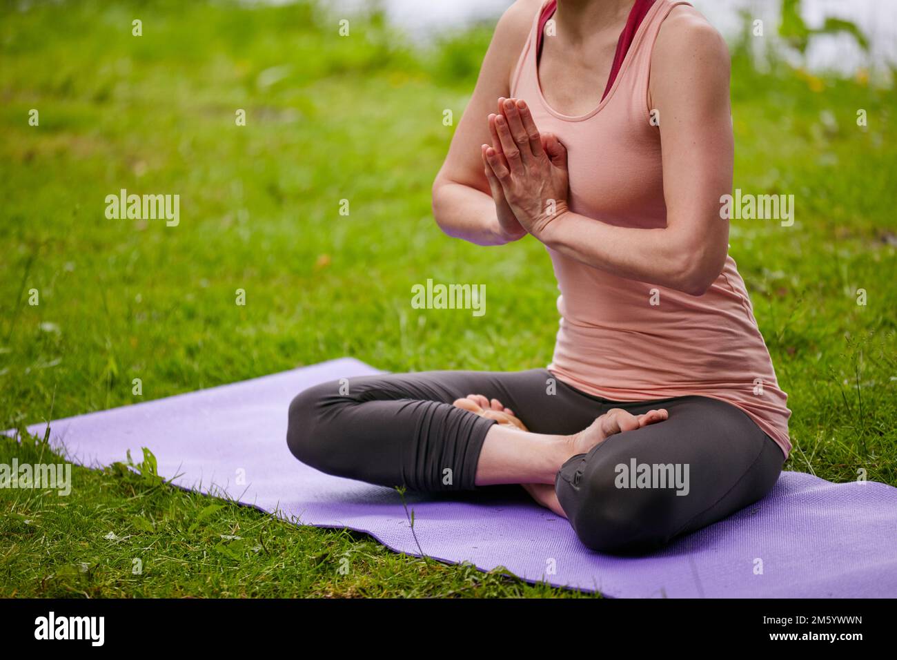 Finding harmony. a woman sitting in the lotus position in the park ...